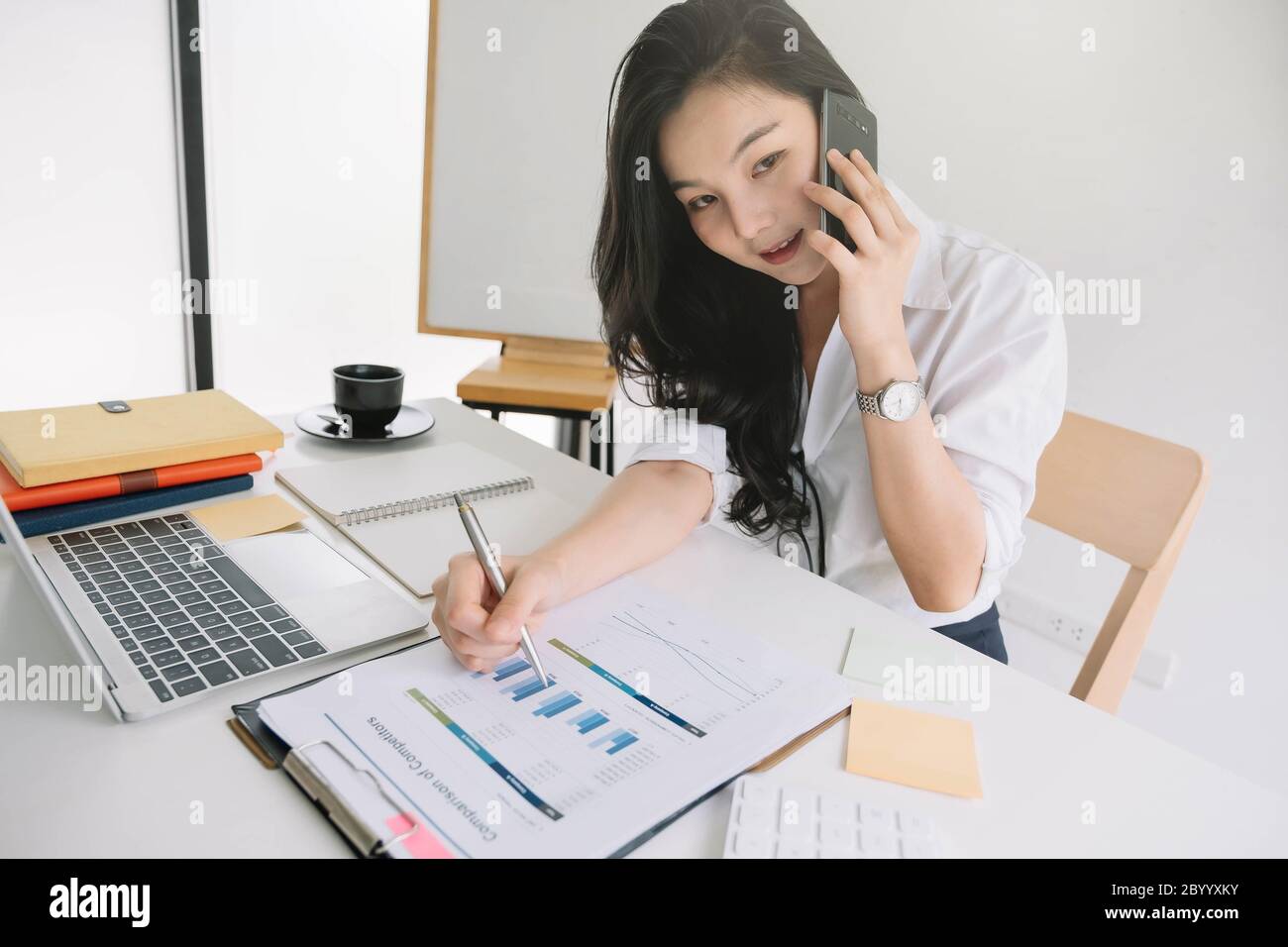 Business woman working with financial document report while talking ...