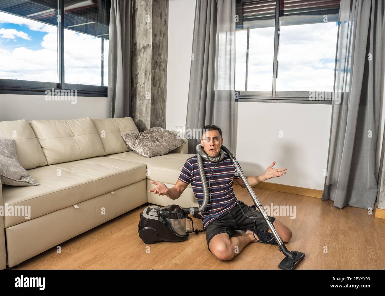 Man desperately trying to understand how a vacuum cleaner works to ...