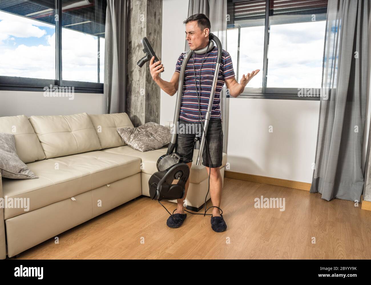 Man desperately trying to understand how a vacuum cleaner works to ...