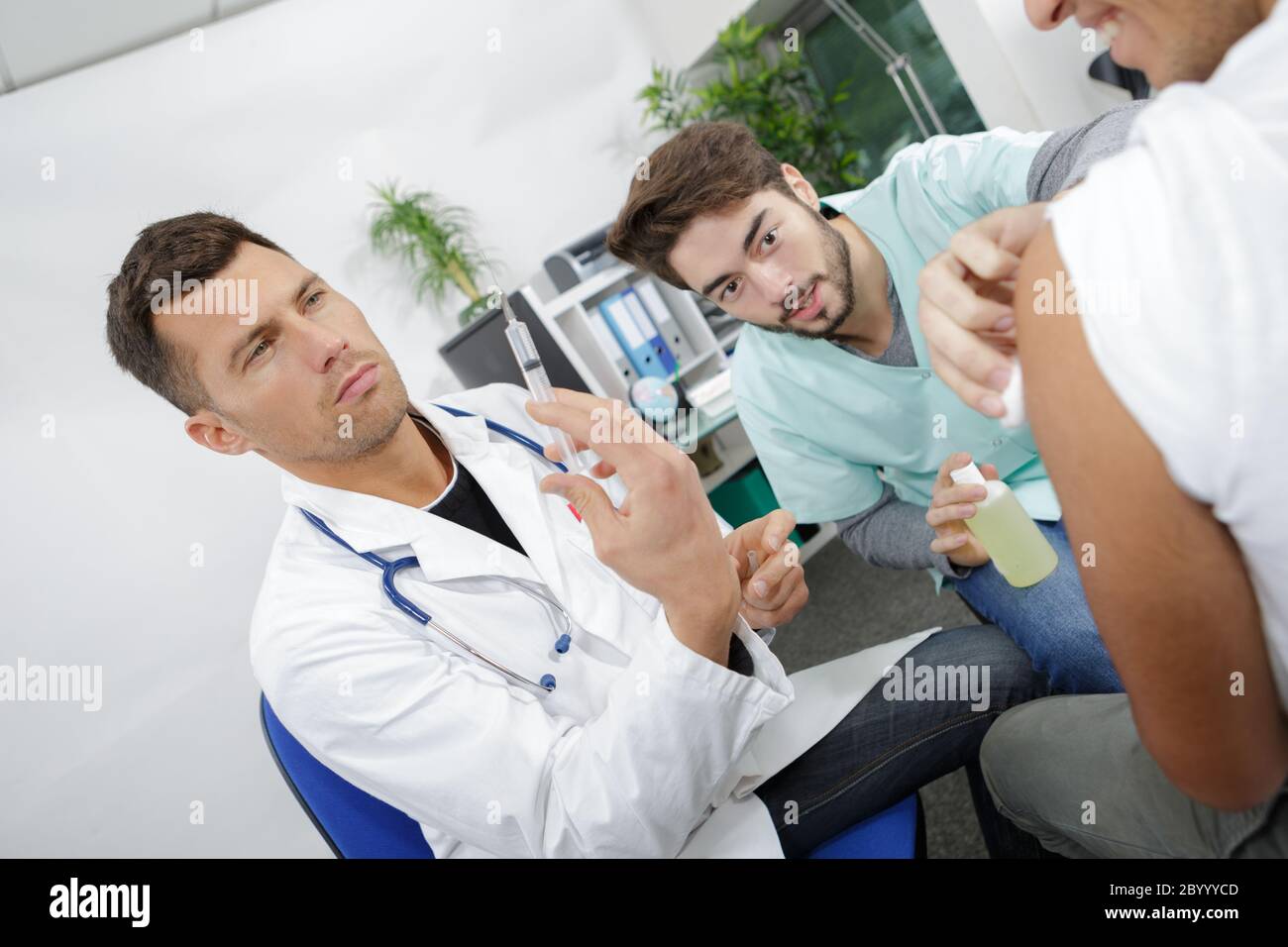 doctor checking dose in syringe for young male patient Stock Photo - Alamy