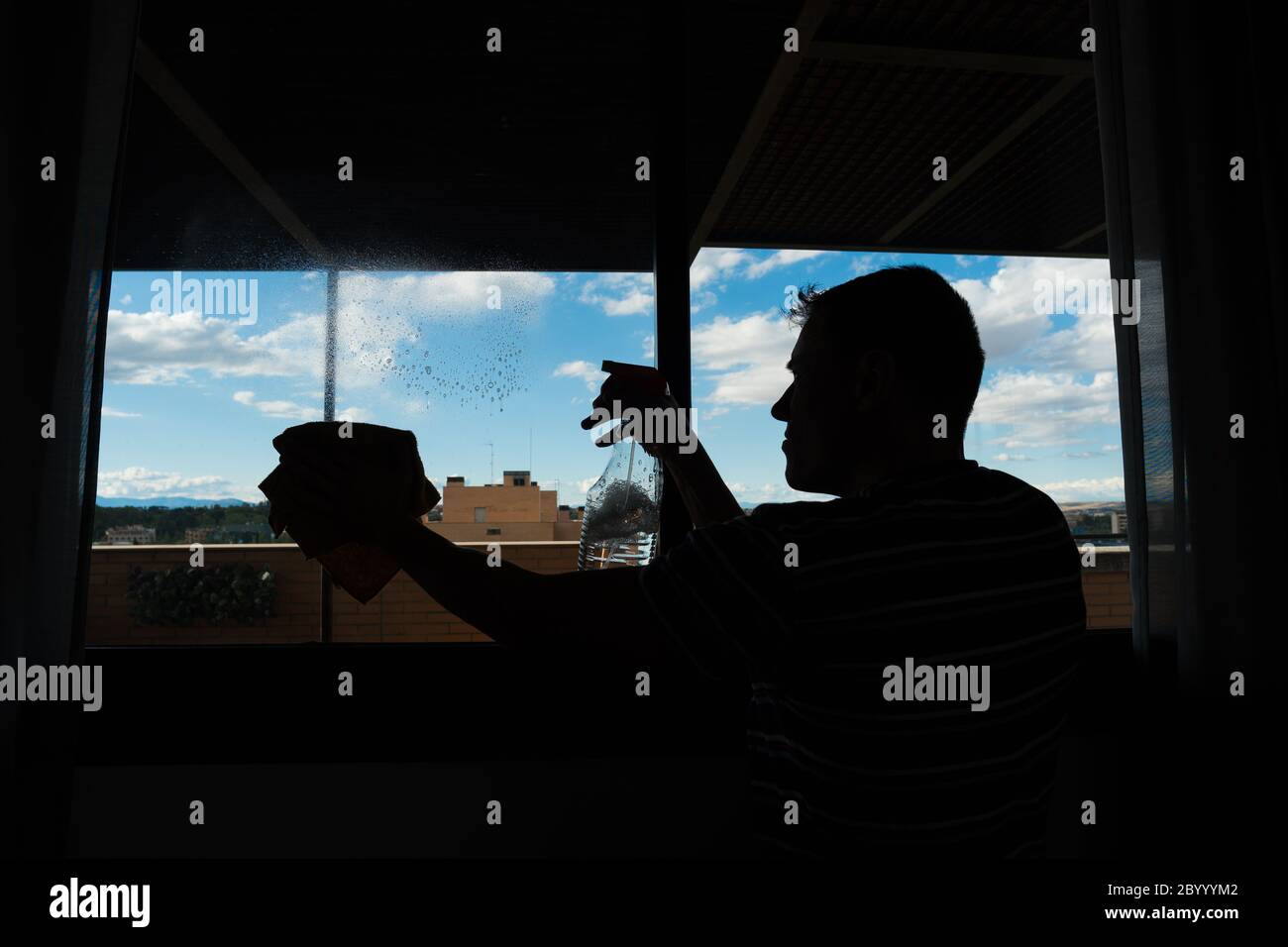 Man cleaning the windows at home. Full body Stock Photo - Alamy