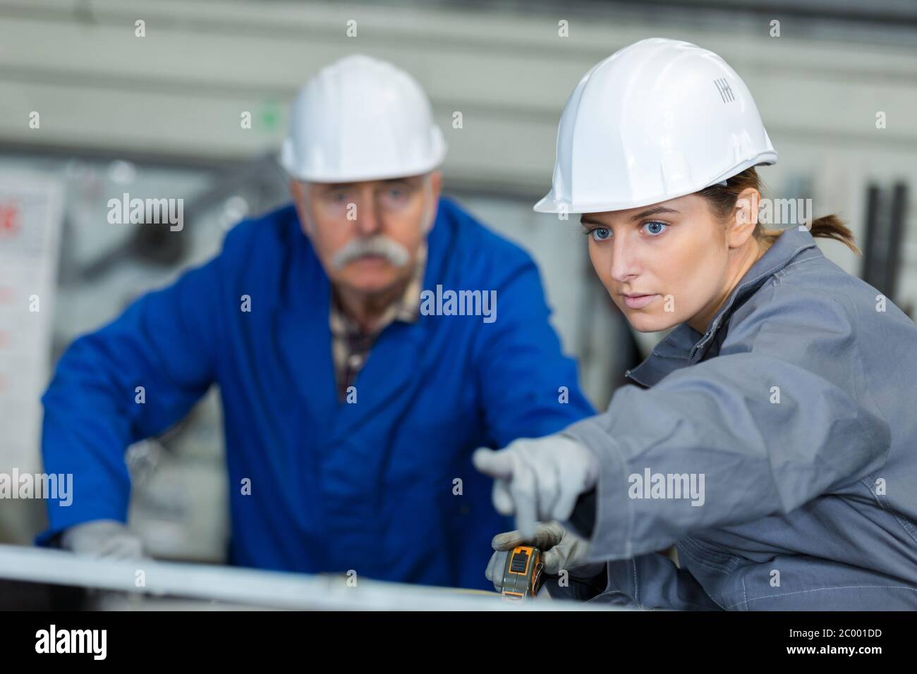 woman pointing at machines with senior factory worker Stock Photo - Alamy