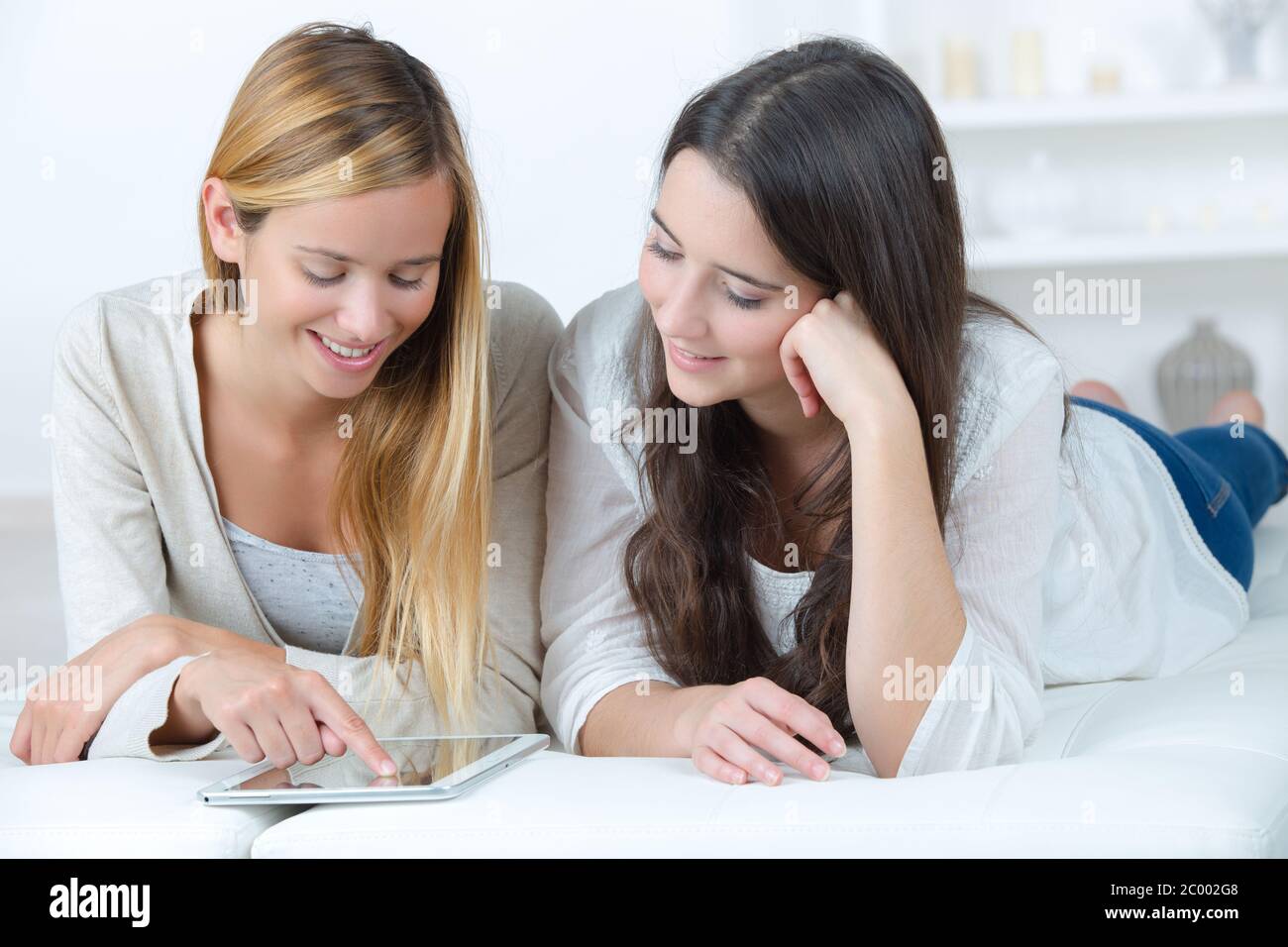 female pals sharing tablet information Stock Photo - Alamy