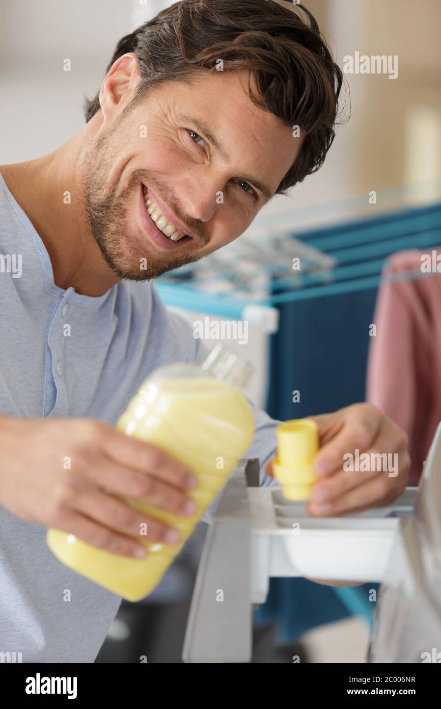 happy man loading the washing machine Stock Photo - Alamy