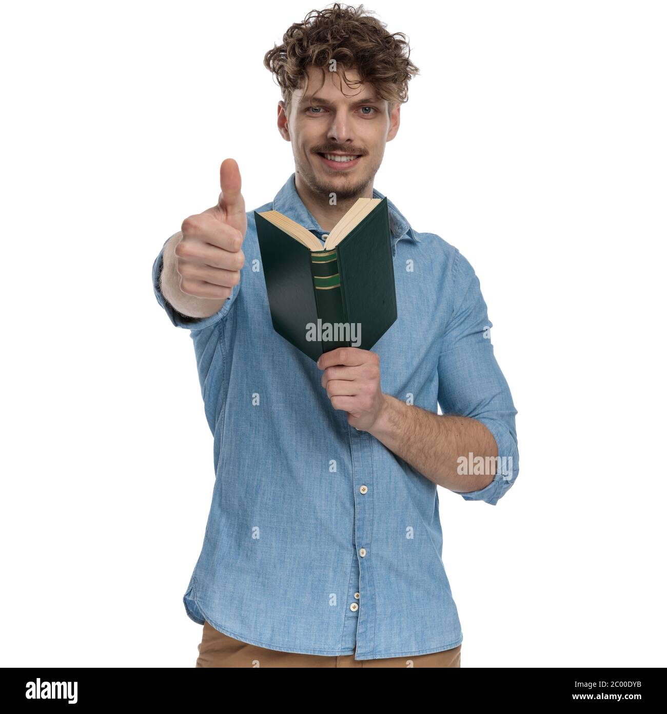 happy young guy reading book and making thumbs up sign, standing ...