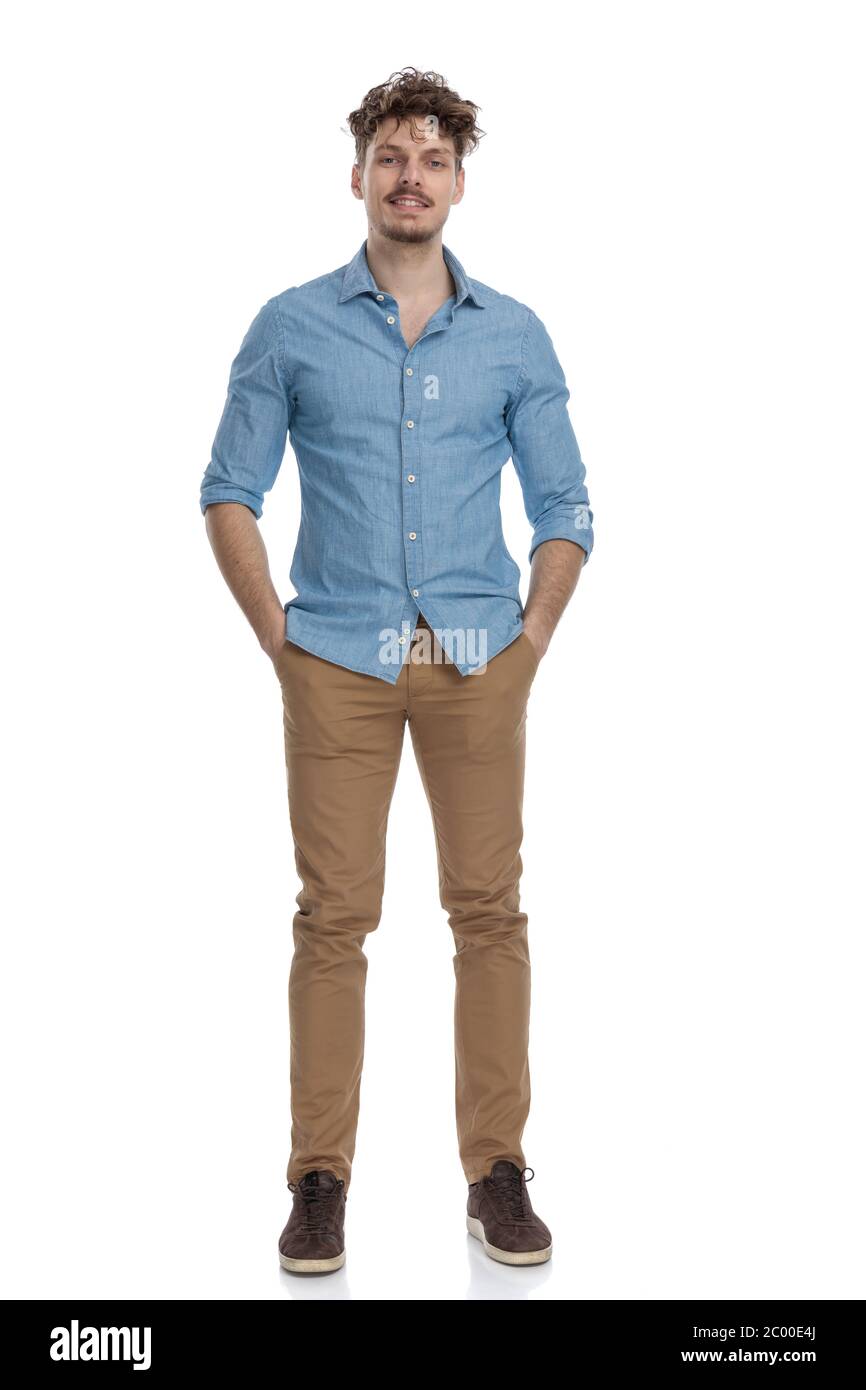 attractive casual guy in denim shirt holding hands in pockets and ...