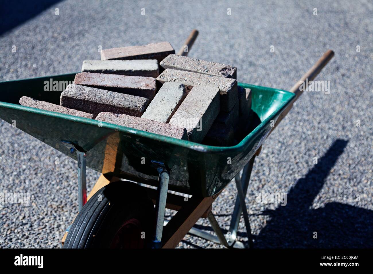 a green wheelbarrow filled with curbs from the front Stock Photo - Alamy