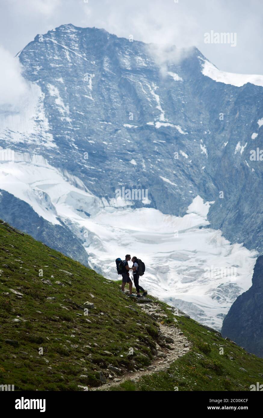 Couple of tourists hiking in Swiss Alps, man and woman standing on a ...