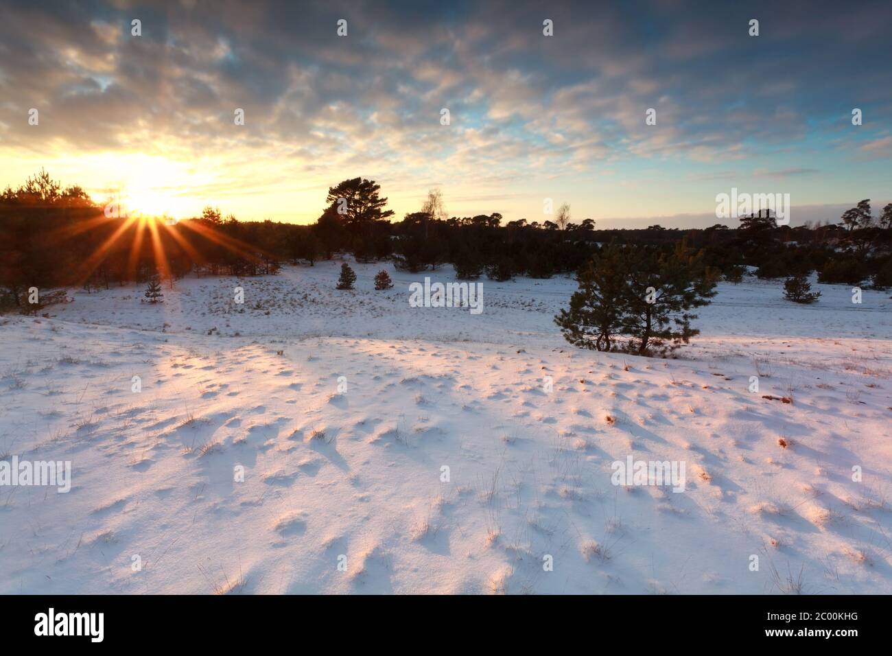 sunset over snowy hills Stock Photo - Alamy