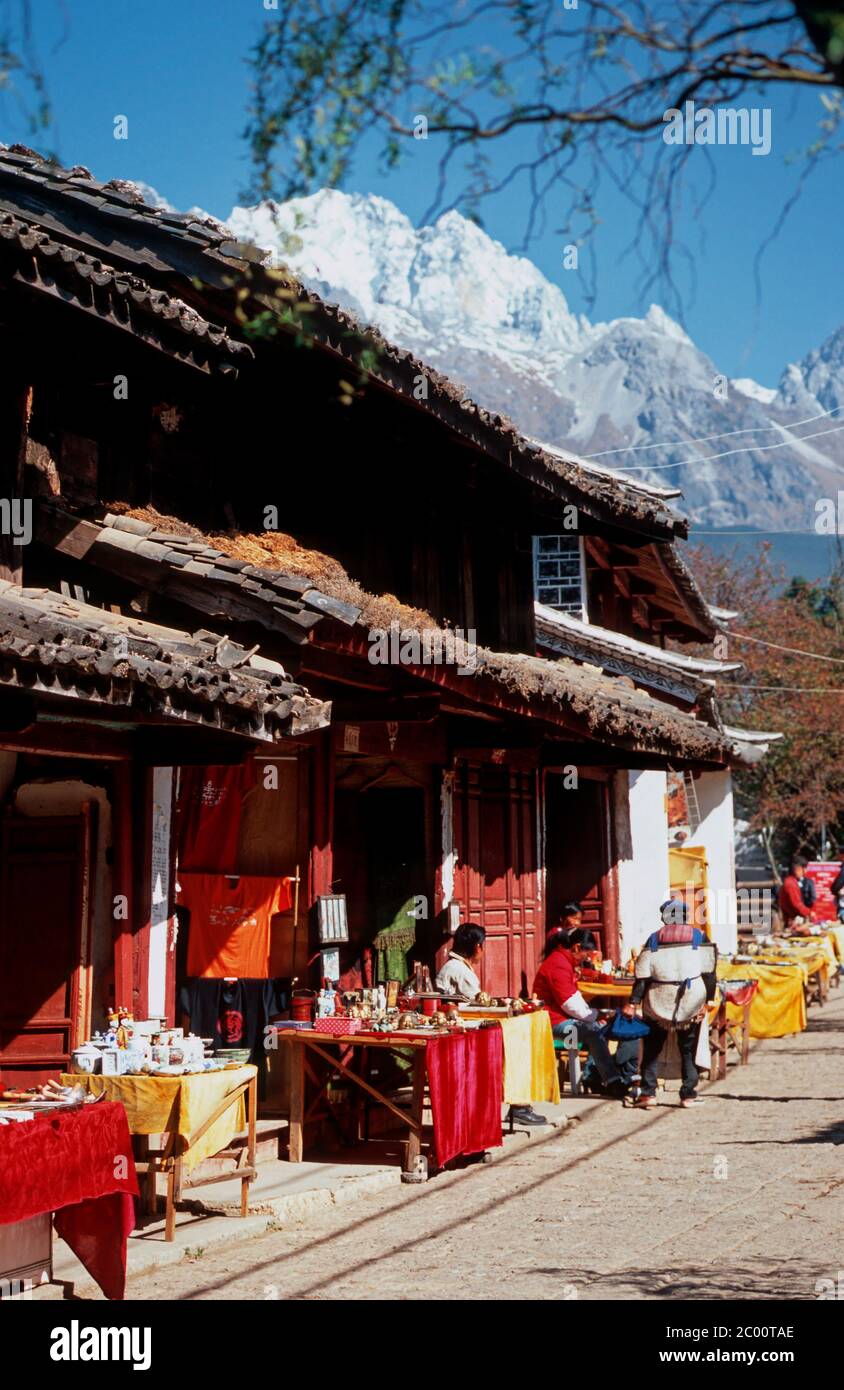 MAIN STREET IN BAISHA WITH YULONG XUE SHAN MOUNTAIN IN THE BACKGROUND ...