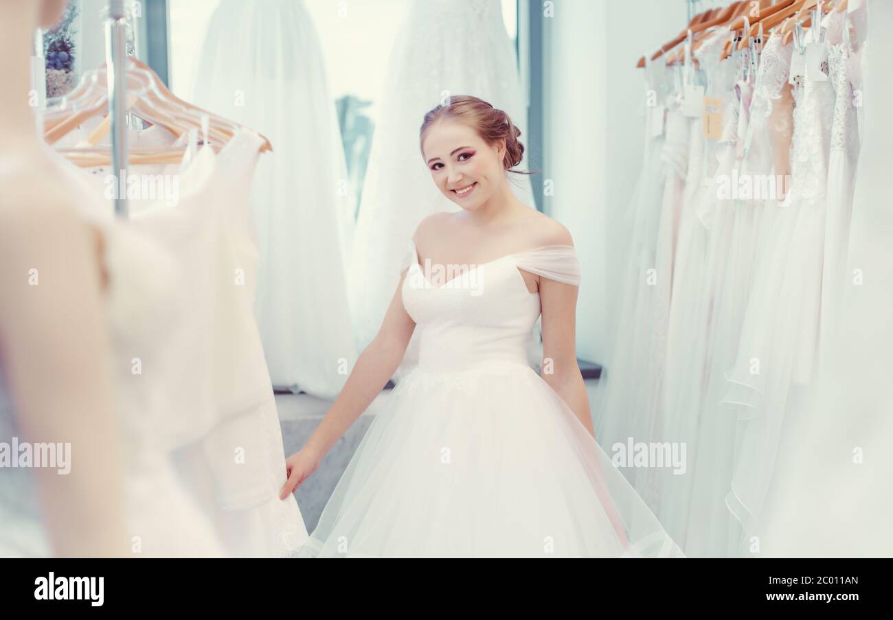 Young woman shopping in wedding shop for a dress to wear as a bride ...