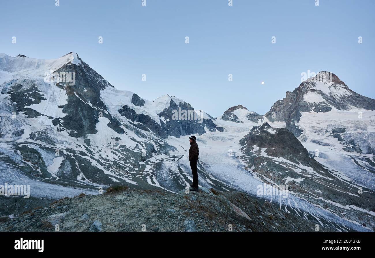 Side view of alone tourist enjoying beautiful mountains scenery, moon ...