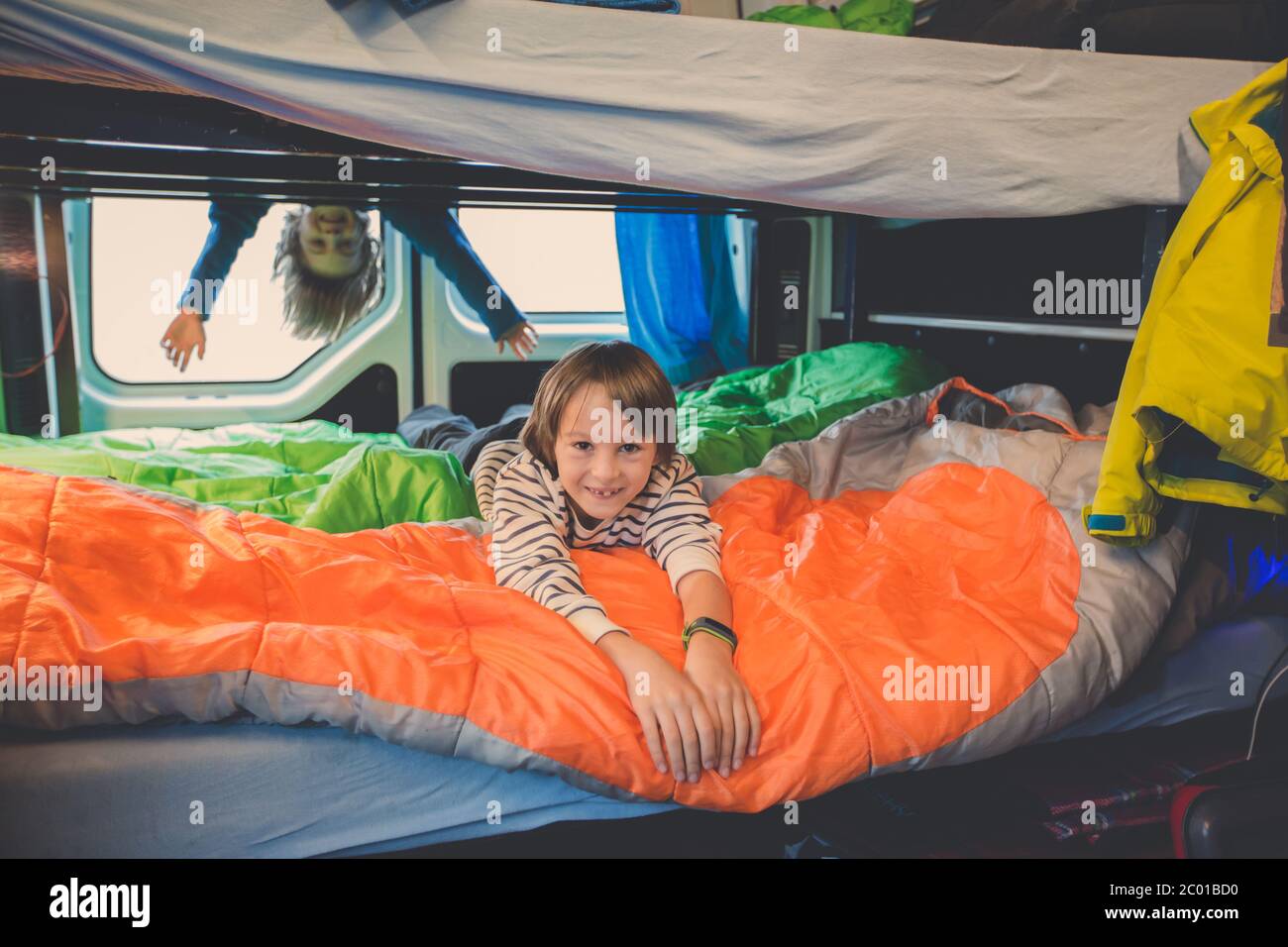 Children, having fun in camper van while heavy raining outdoors ...