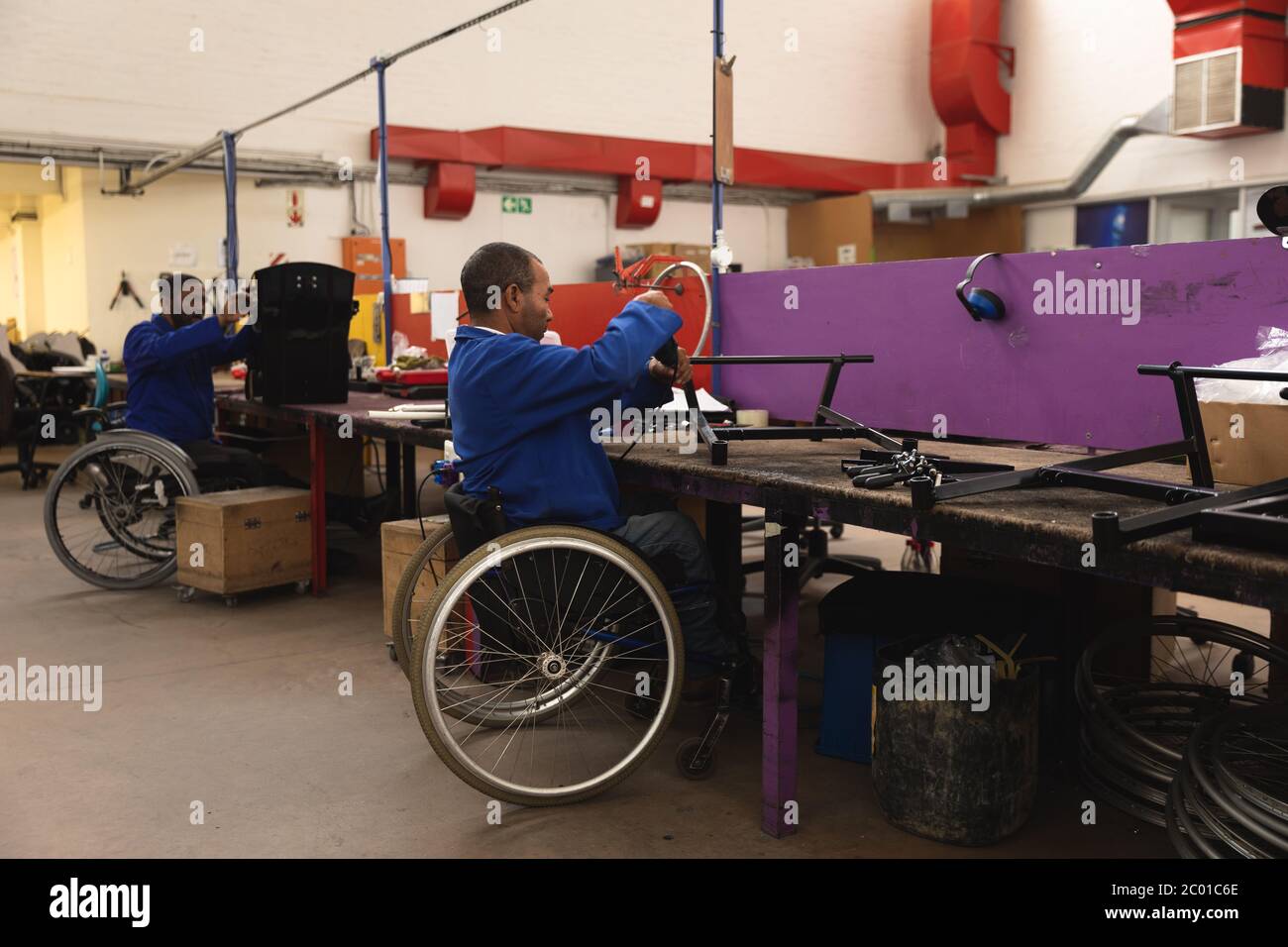 Multi races workers assembling wheelchairs parts Stock Photo - Alamy