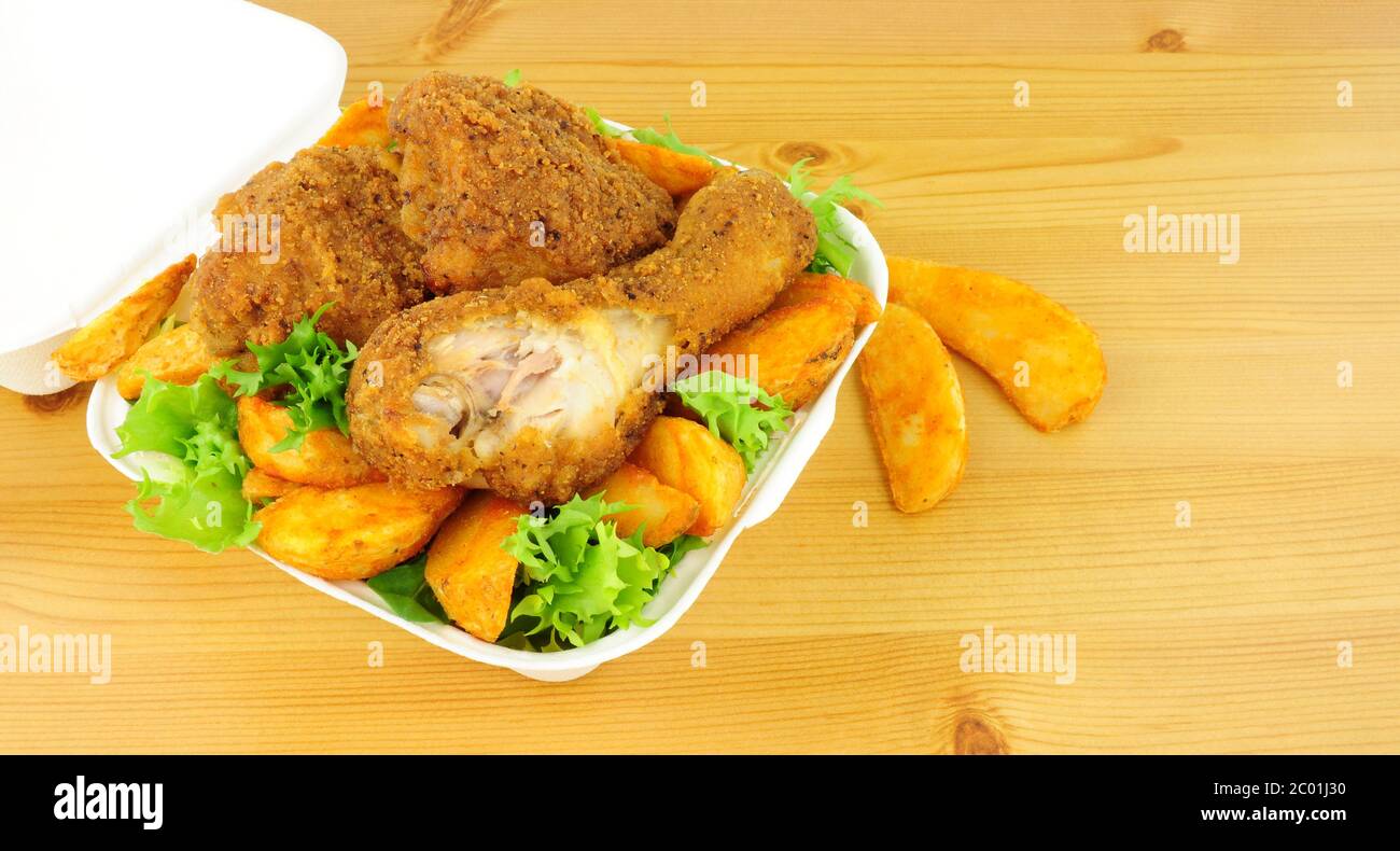 Southern fried chicken portions in a take away box on a wood background ...