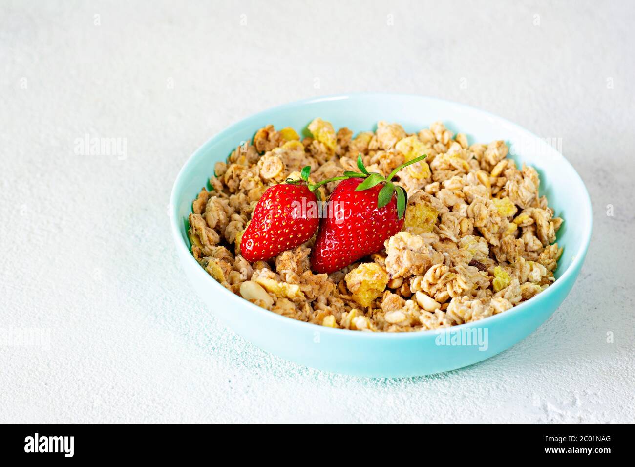 Homemade crunchy granola with nuts, dried fruits, fresh strawberries ...
