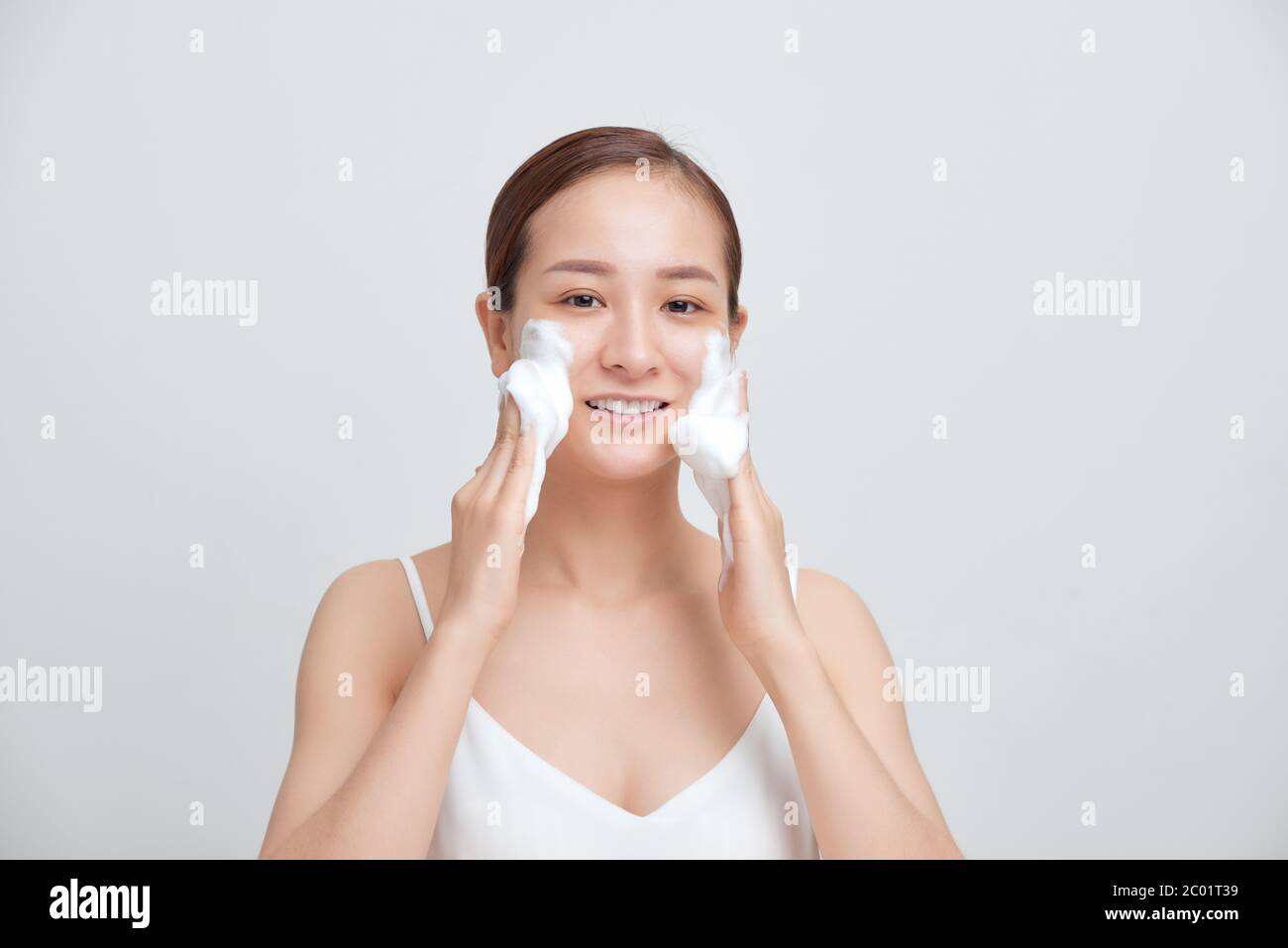 Portrait of cheerful laughing woman applying foam for washing on her ...