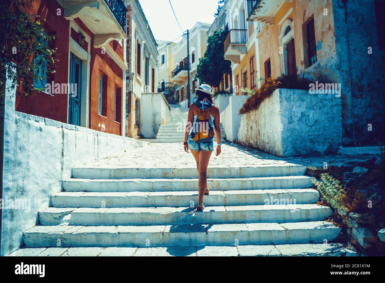Happy woman traveler is walking and exploring Greek island of Symi ...