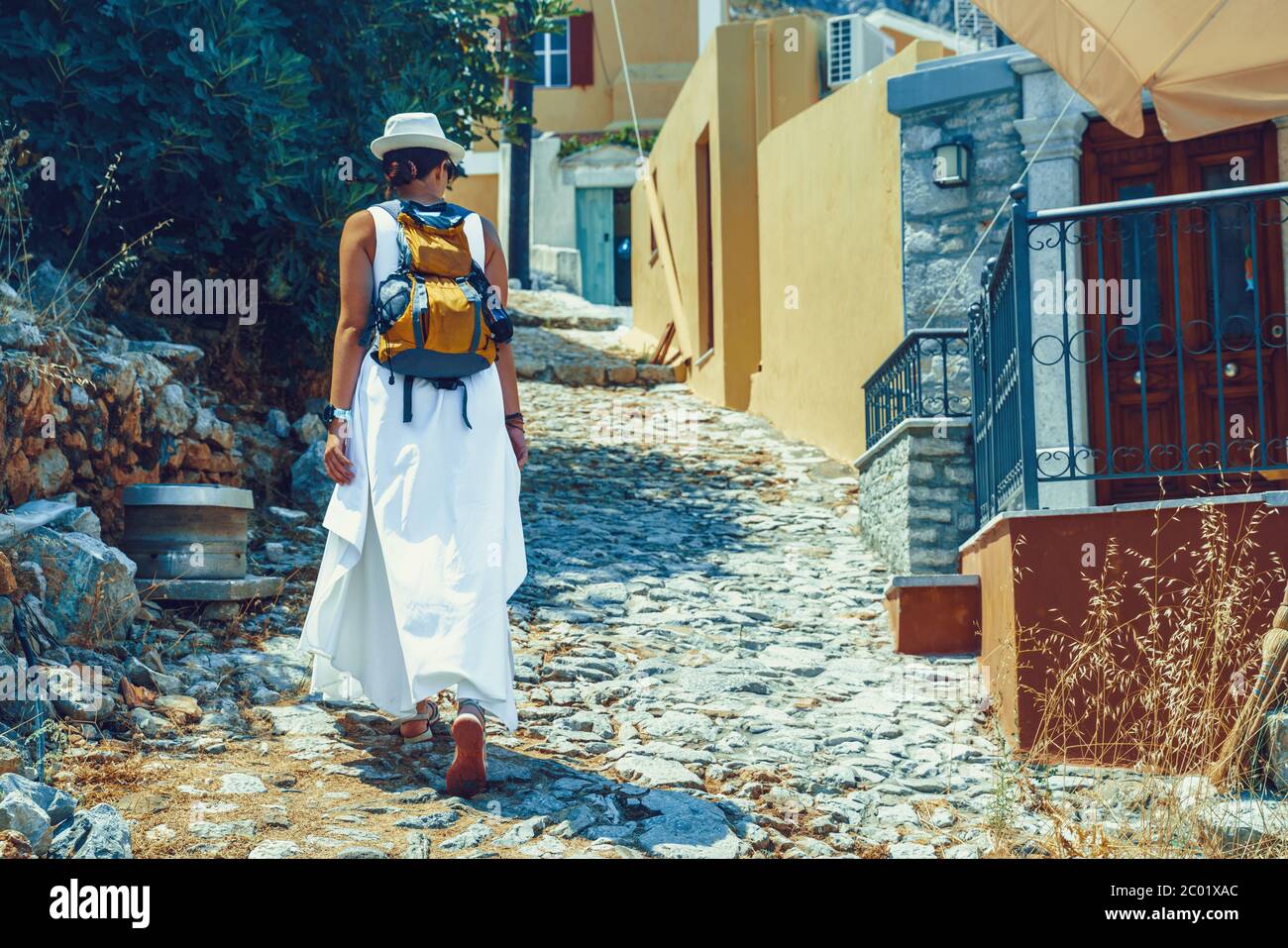 Happy woman traveler is walking and exploring Greek island of Symi ...