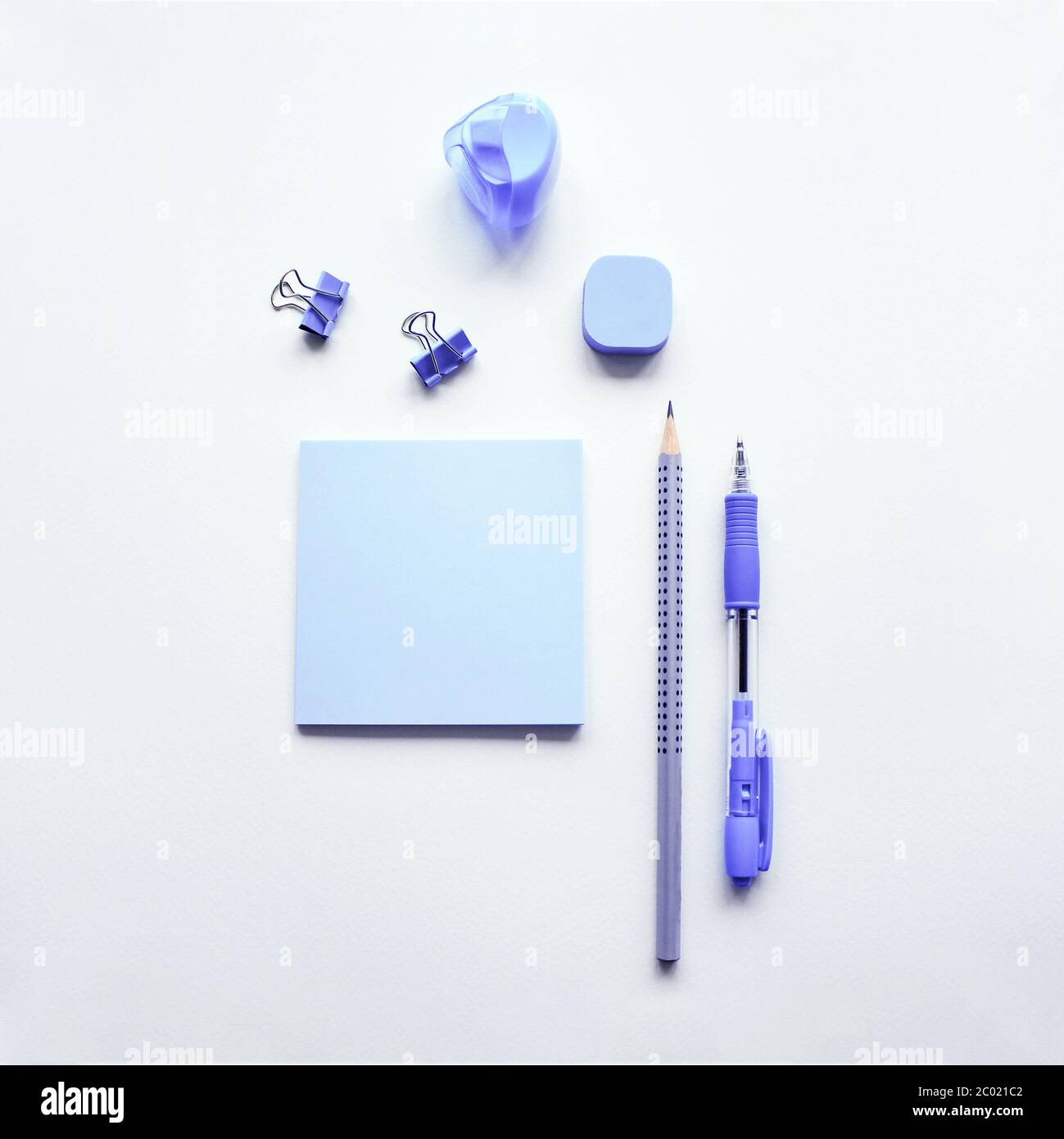 Variety of office supplies in lilac color on white desk background ...