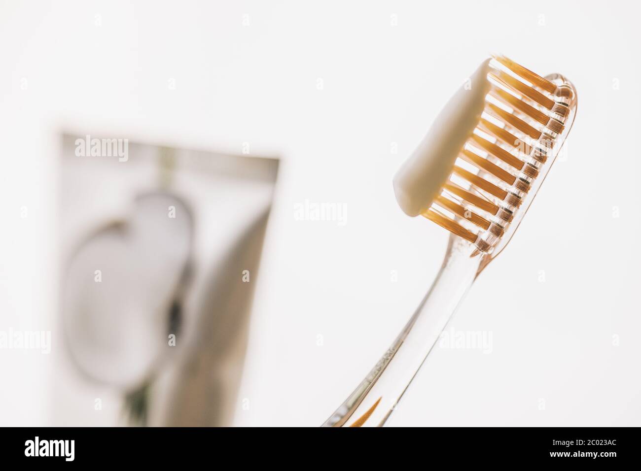 plastic toothbrush closeup, toothpaste on white blurred background ...