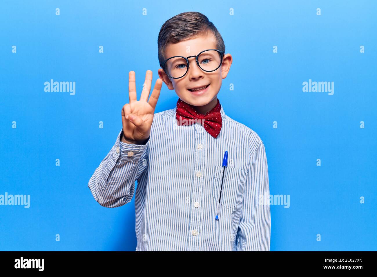 Cute blond kid wearing nerd bow tie and glasses showing and pointing up ...
