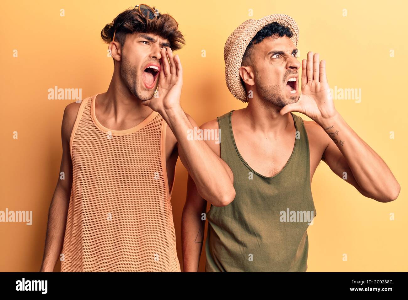 Young gay couple wearing summer clothes shouting and screaming loud to ...