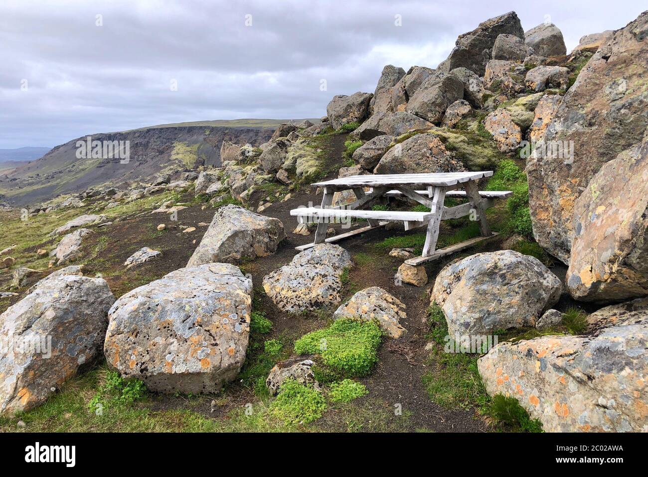 Wooden picnic table sits on the rocks overlooking the mountains in the ...