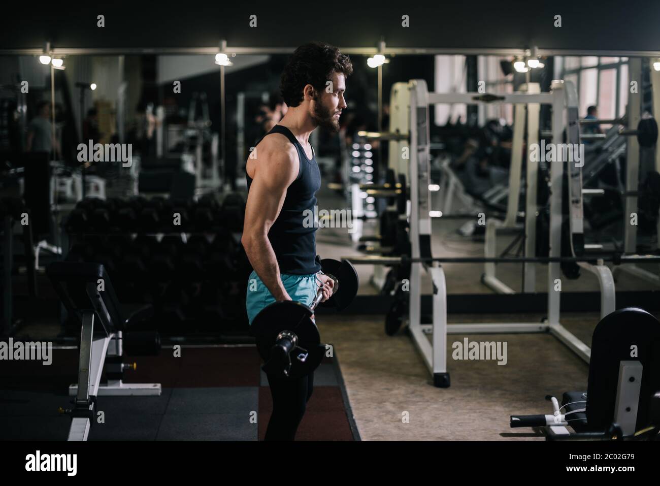 Side view of handsome bearded young man with muscular wiry body wearing ...