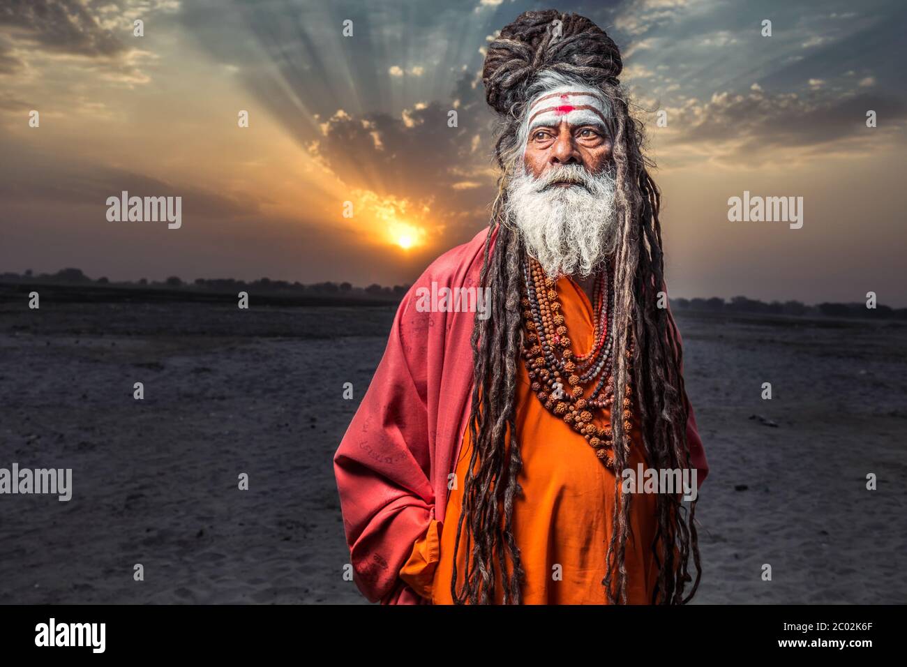 Portrait of sadhu standing with sunrise behind him, Varanasi, India ...