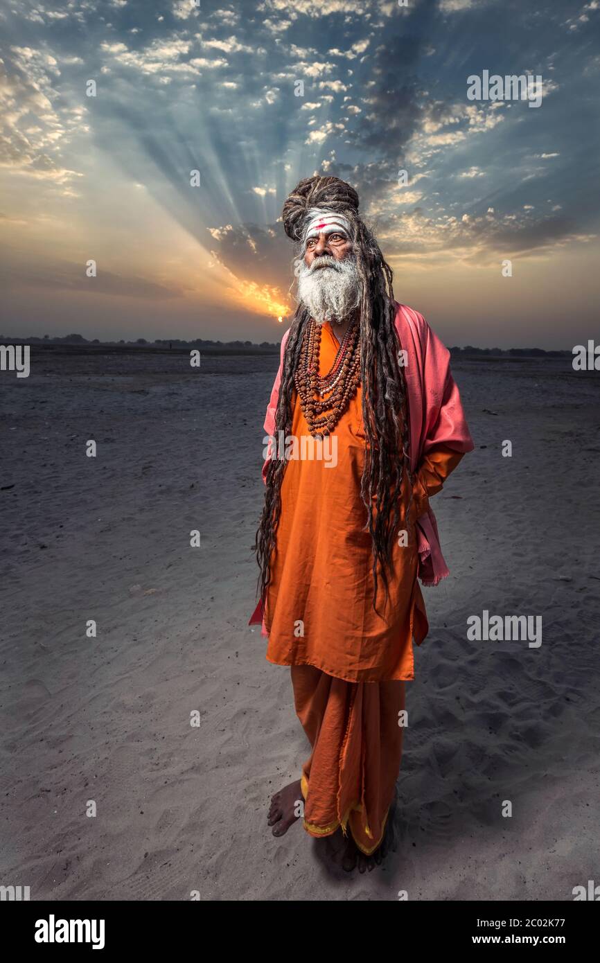 Portrait of sadhu standing with sunrise behind him, Varanasi, India ...