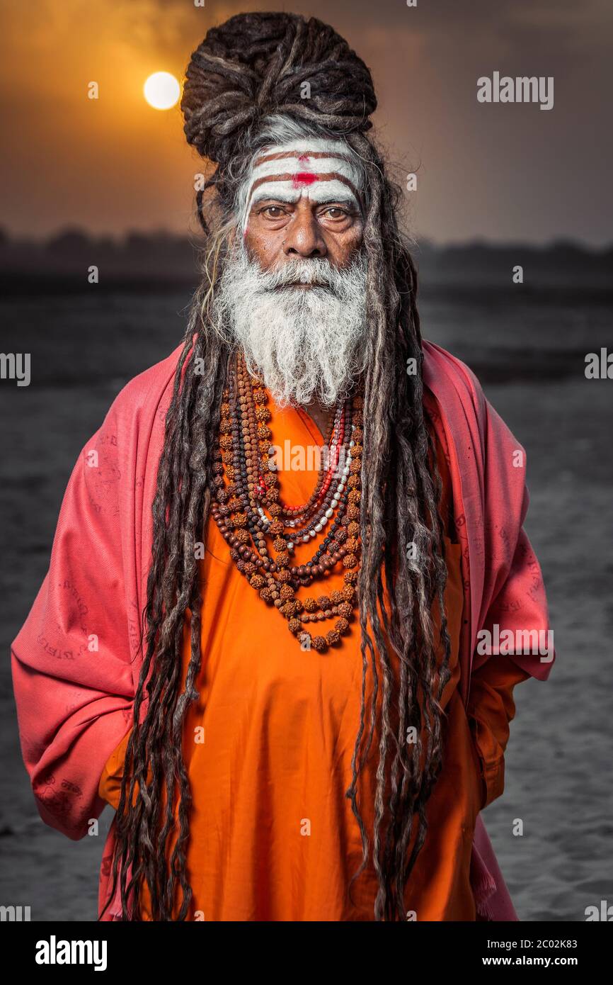 Portrait of sadhu standing with sunrise behind him, Varanasi, India ...