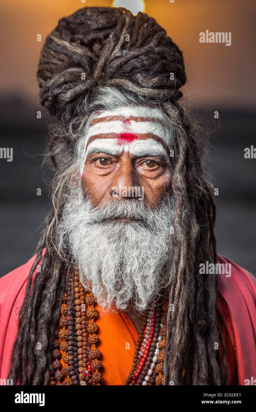 Portrait of sadhu standing with sunrise behind him, Varanasi, India ...