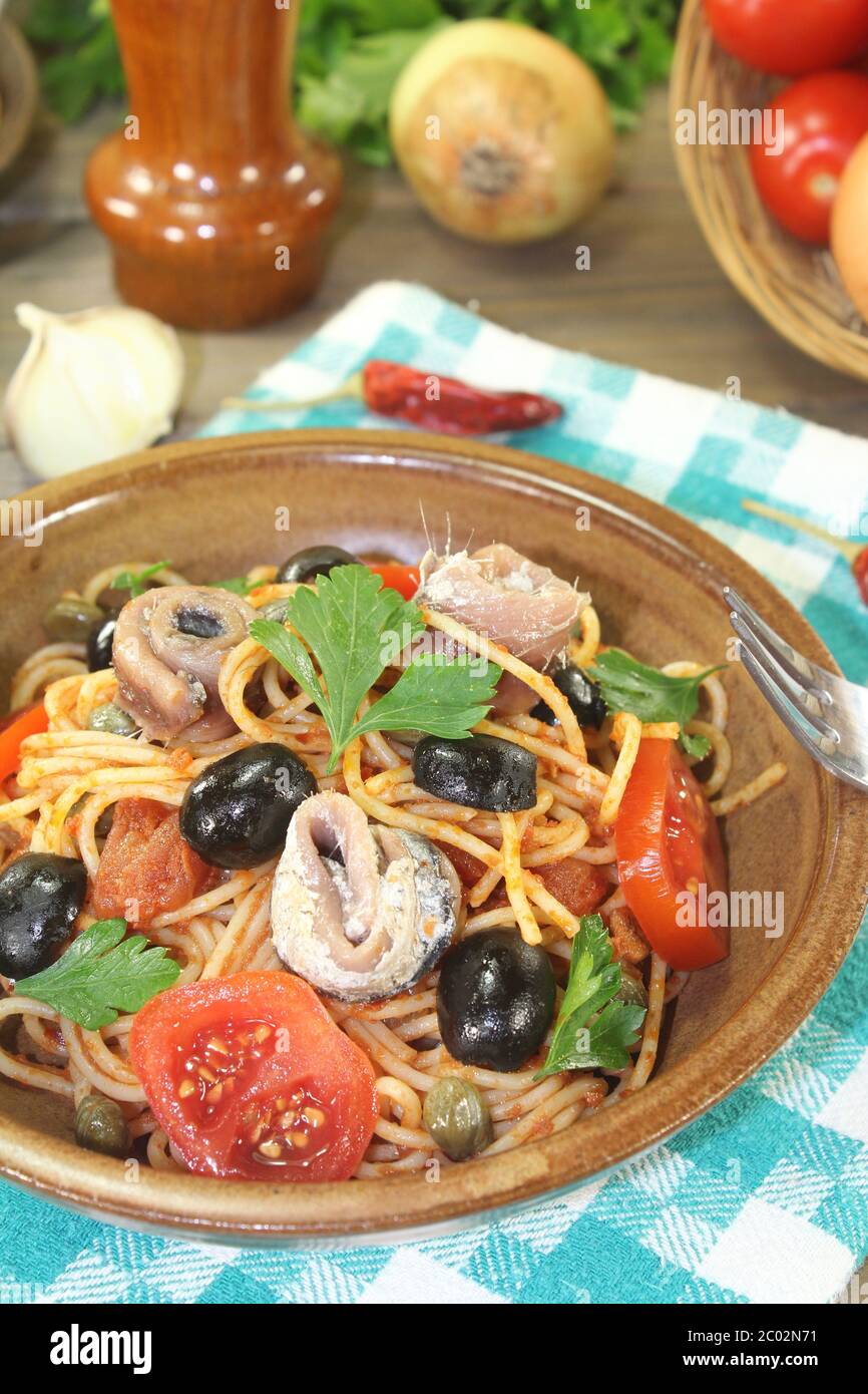 Spaghetti alla puttanesca with olives and anchovie Stock Photo - Alamy