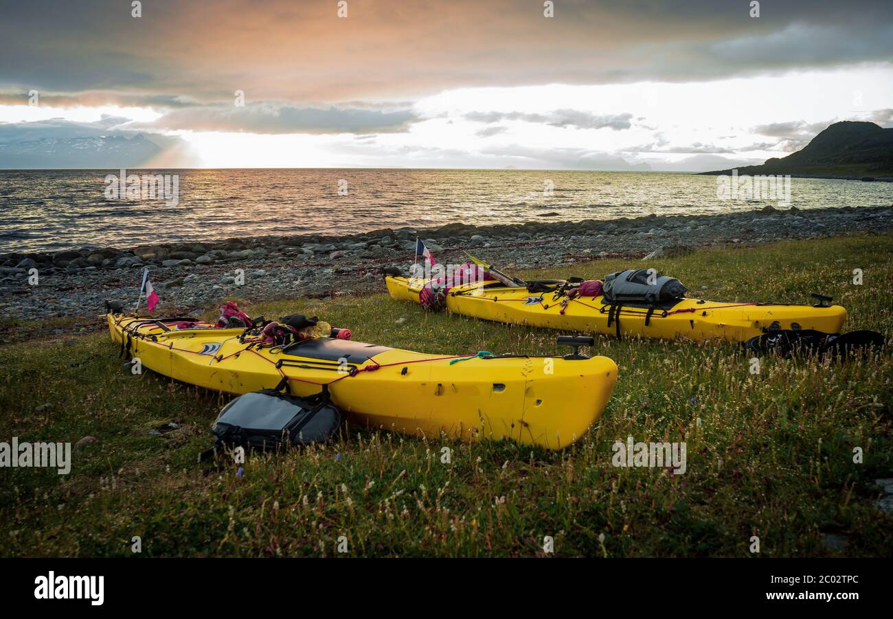 Two yellow kayaks on the beach during a vibrant summer sunset. Taken in ...