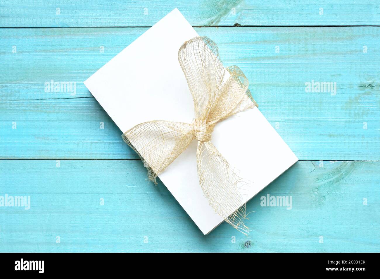 Blank papers to write letters tied with a raffia ribbon on an old white ...