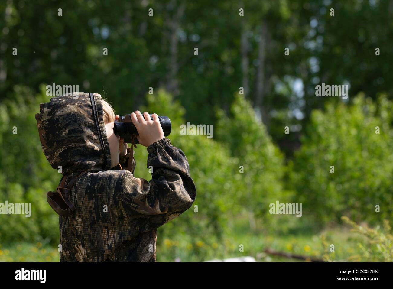 Little boy with binoculars in forest looking for discoveries, doing ...