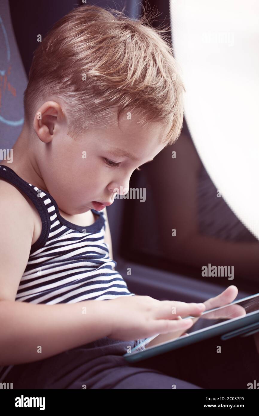 Little child using touch pad while traveling by bus Stock Photo - Alamy
