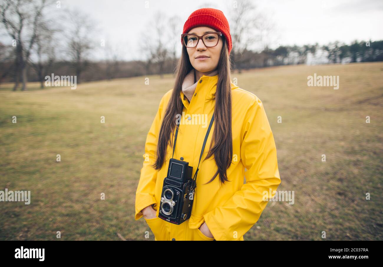 Woman photographer in yellow raincoat with vintage camera Stock Photo ...