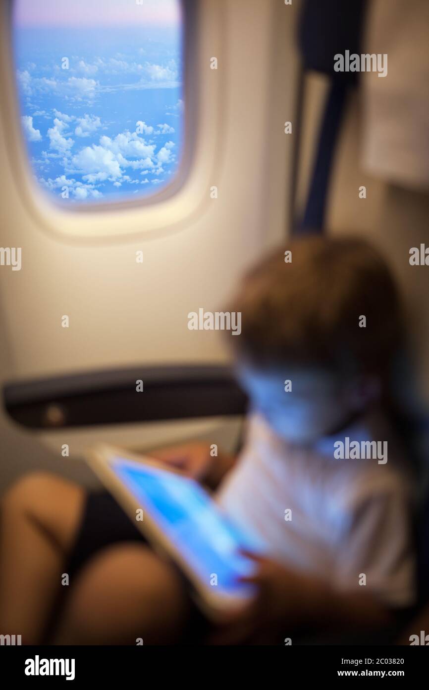 Child with pad in flying plane Stock Photo - Alamy