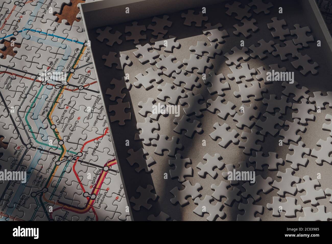 London, UK - May 18, 2020: Box with white puzzle pieces on top of ...