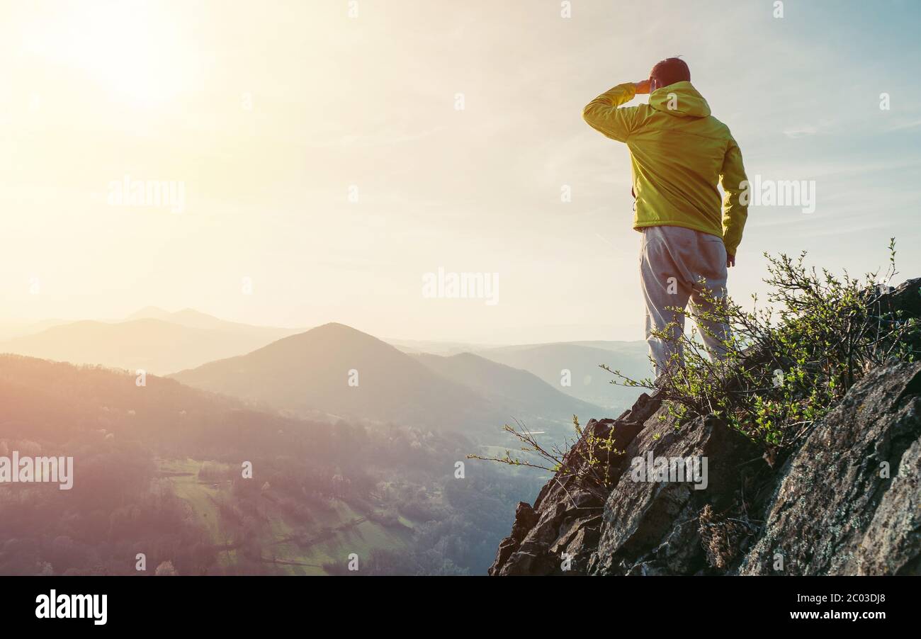 Successful hiker hiking on spring sunrise mountain top. Amazing view to ...