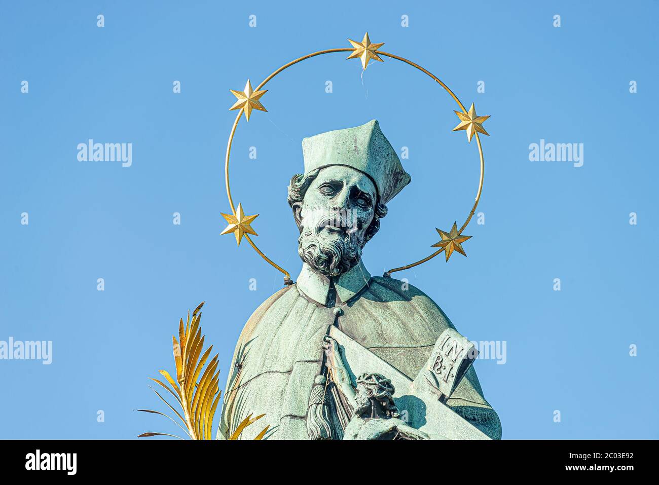 Statue of saint with cross at the Charles Bridge in Prague at blue ...