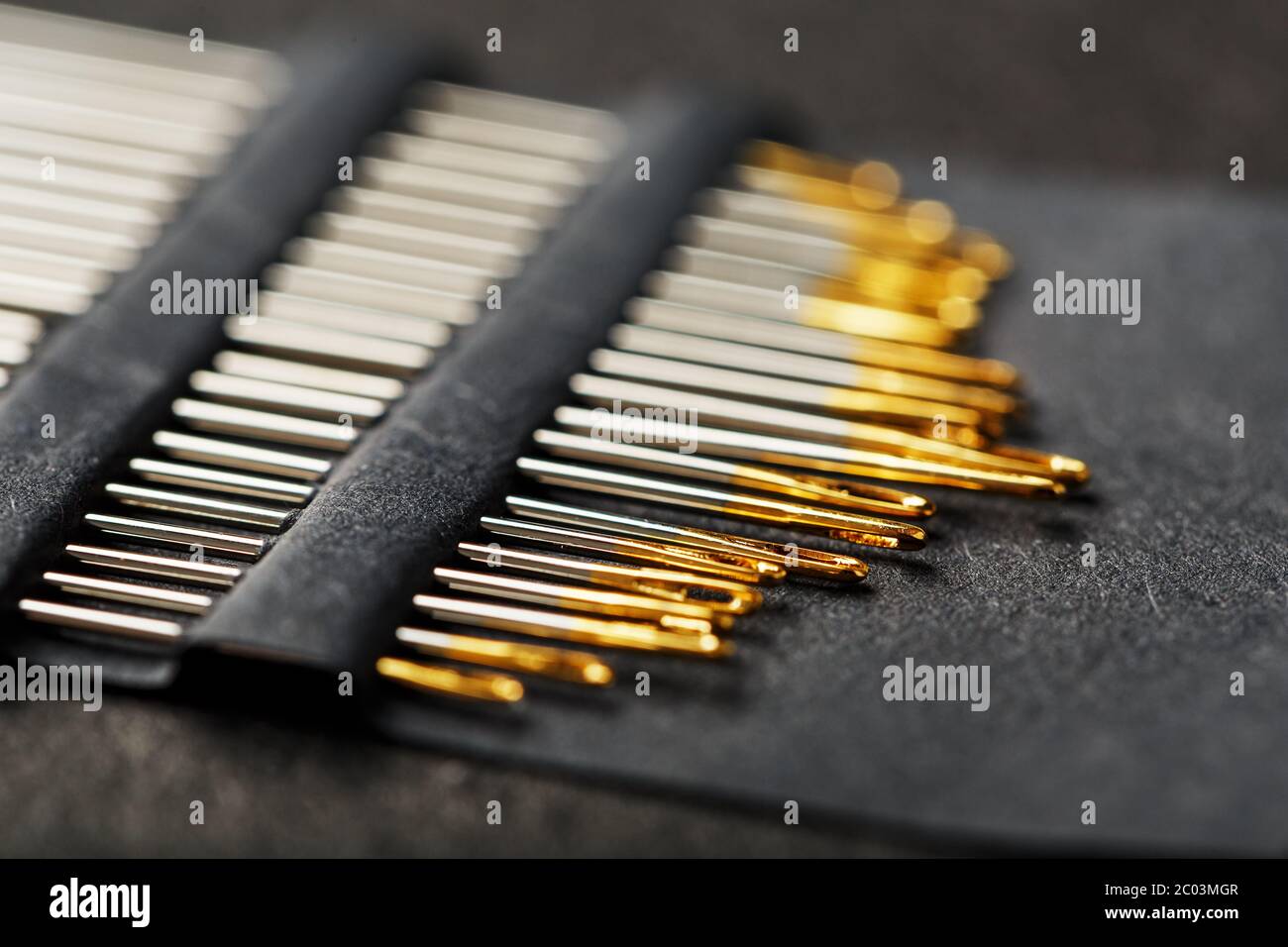 Set of Gold needles on a black background in a row Stock Photo - Alamy