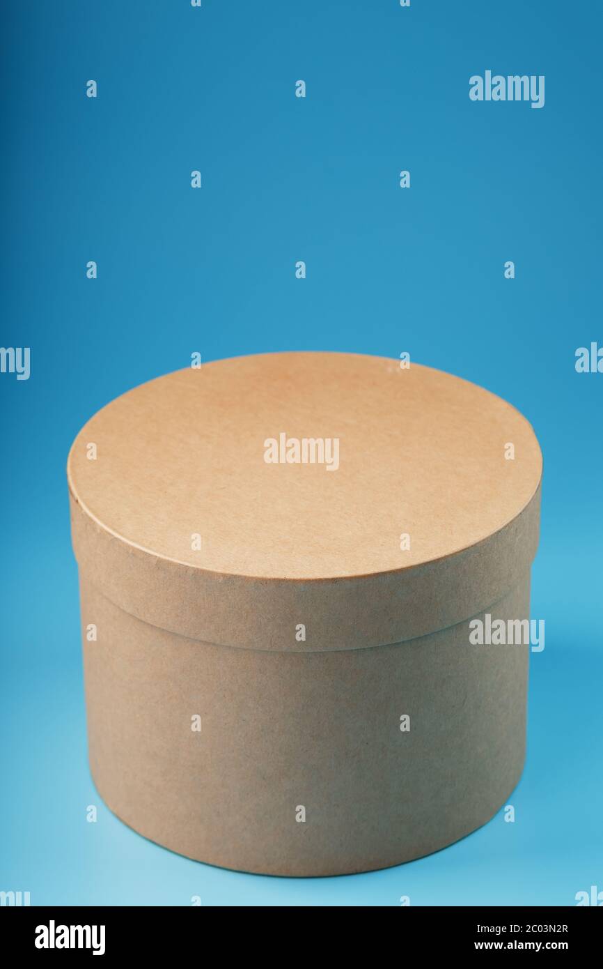 Round cardboard box on a blue background, free space Stock Photo - Alamy