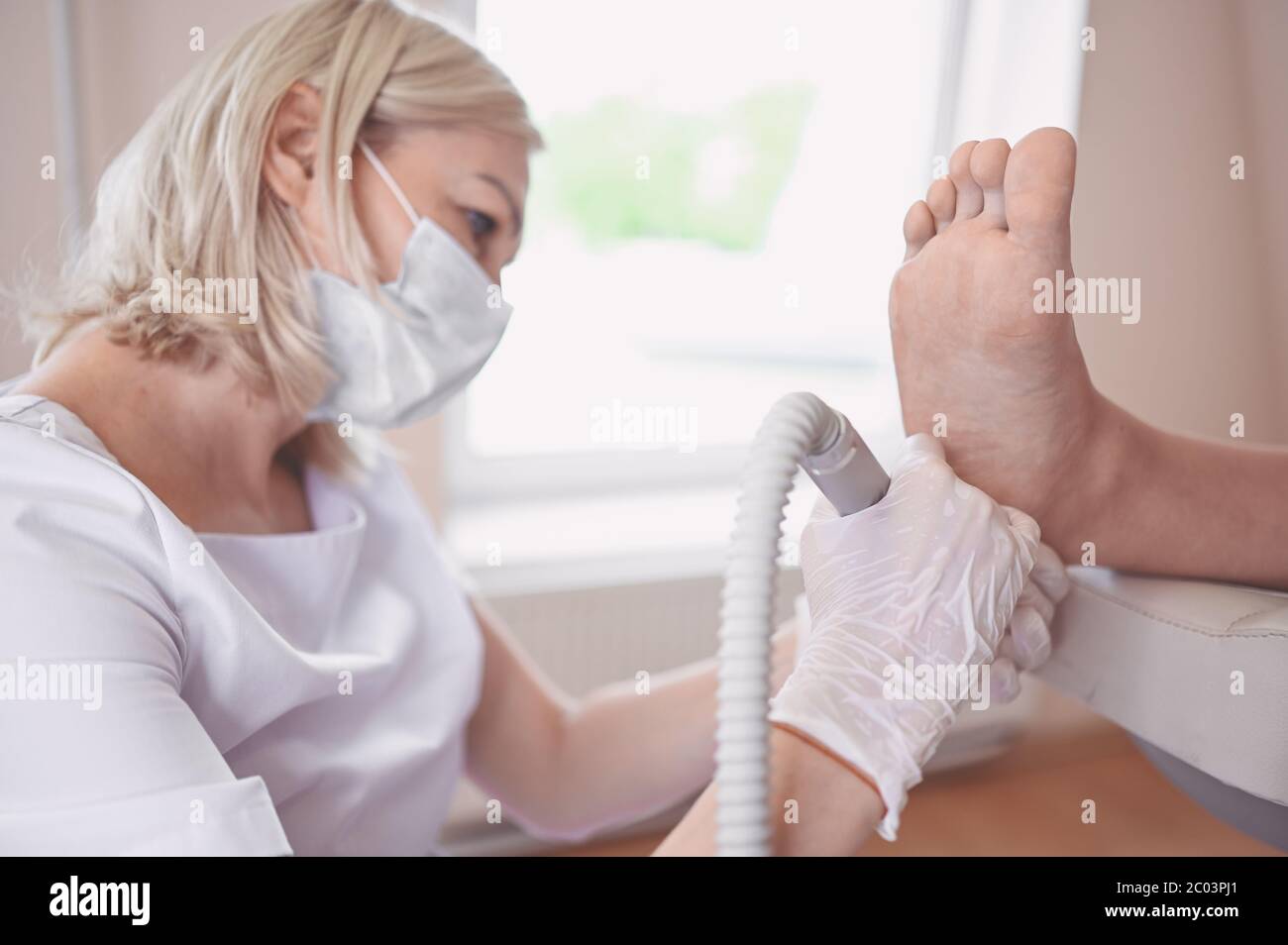 Podiatrist doctor using grinding equipment and making procedure polish ...