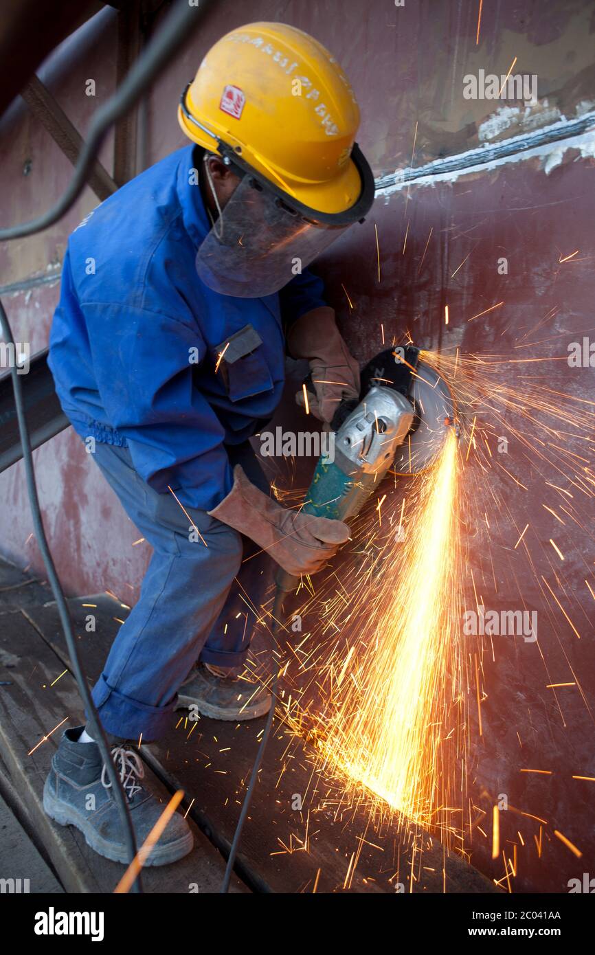 Welder grinding off supports no longer needed during the construction ...