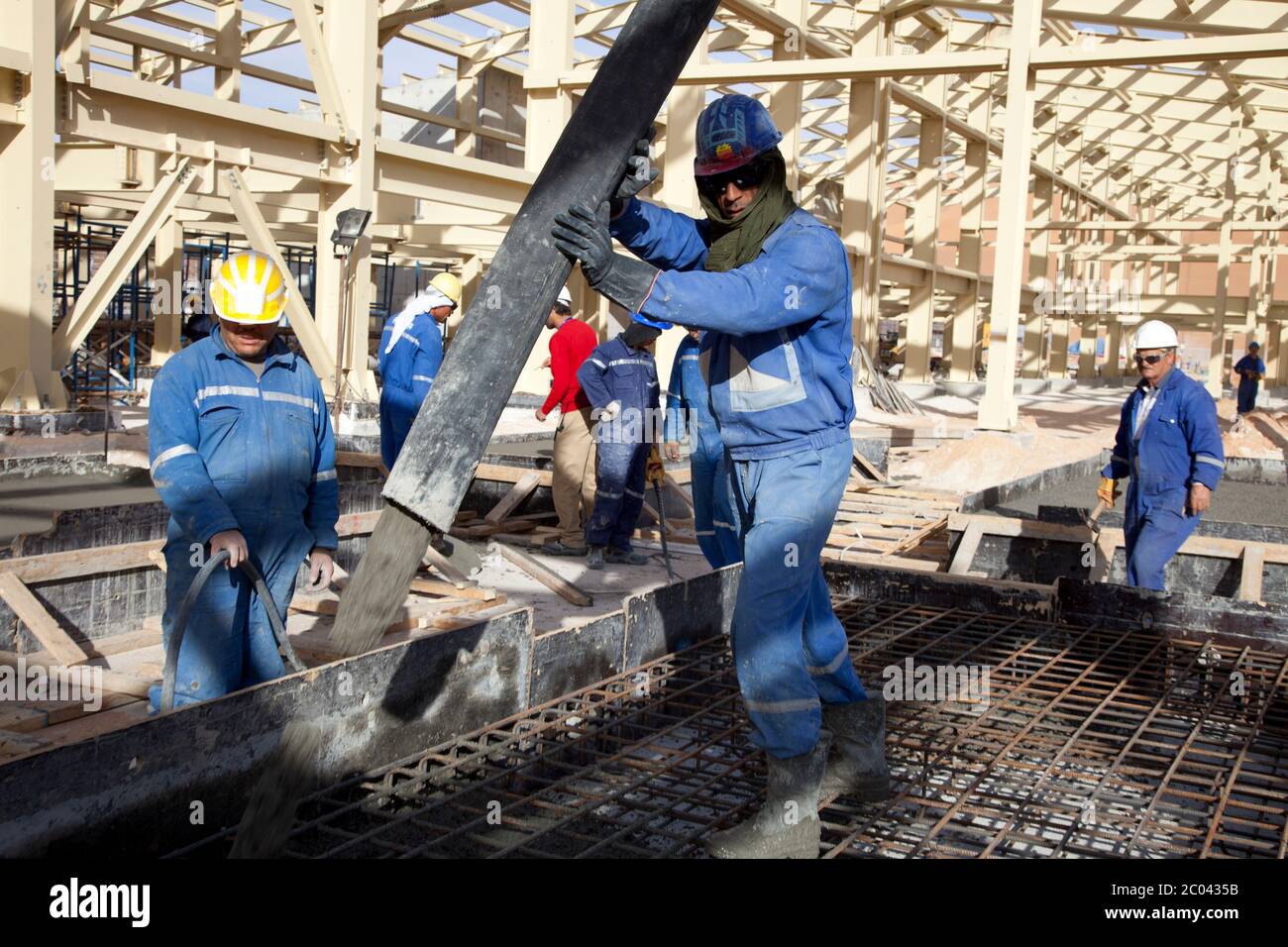 Pouring concrete into shuttering to construct foundations for a large ...