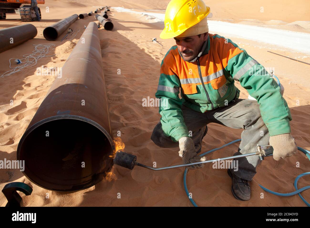 Oil export pipeline pipes in the Sahara desert being heated to burn off ...