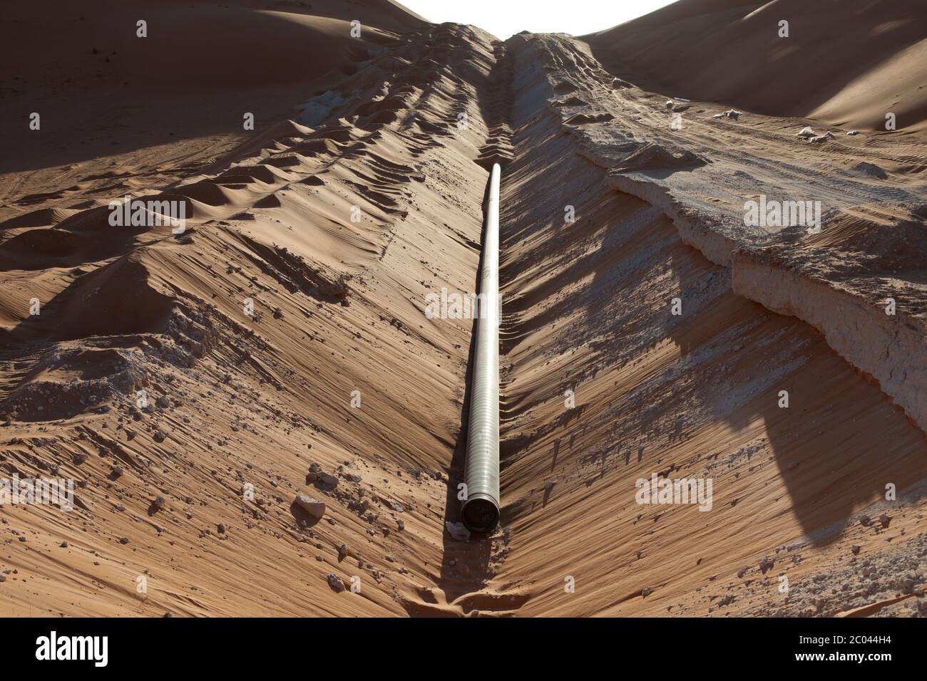 A welded pipeline section sits a trench in the sand in the Sahara ...